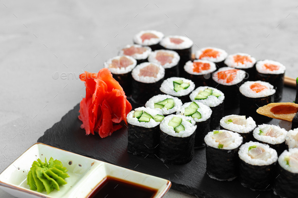 Maki sushi set served on black stone tray Stock Photo by FabrikaPhoto