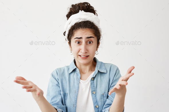 Dark-haired annoyed angry woman in do-rag holding hands in furious ...