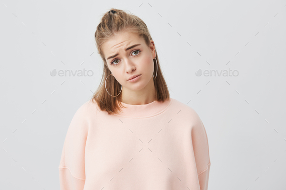 Beautiful young european female with fair hair looking at camera with ...