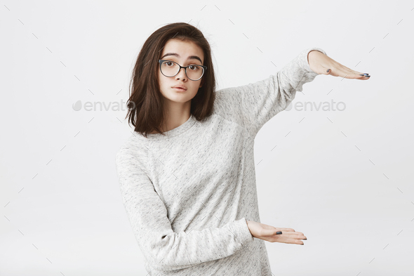 Waist up shot of cute attractive young model showing space on white ...