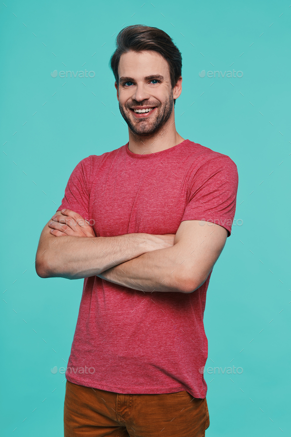 Handsome young man in casual clothing looking at camera and smiling ...