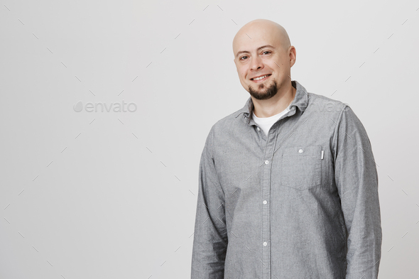 Portrait of good-looking bald man in casual clothes joyfully smiling ...