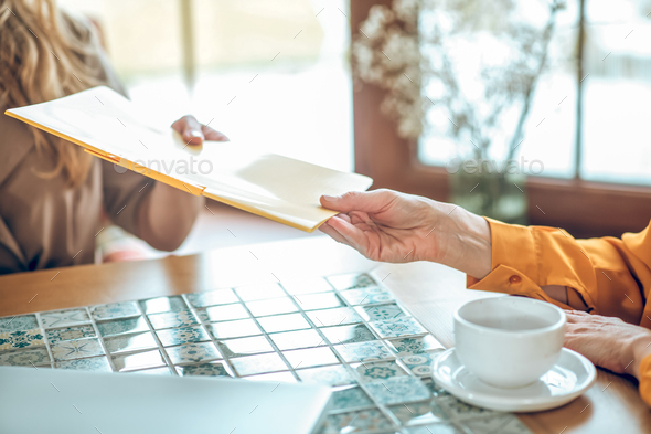Close up of a female hand passing the papers to the client Stock Photo ...