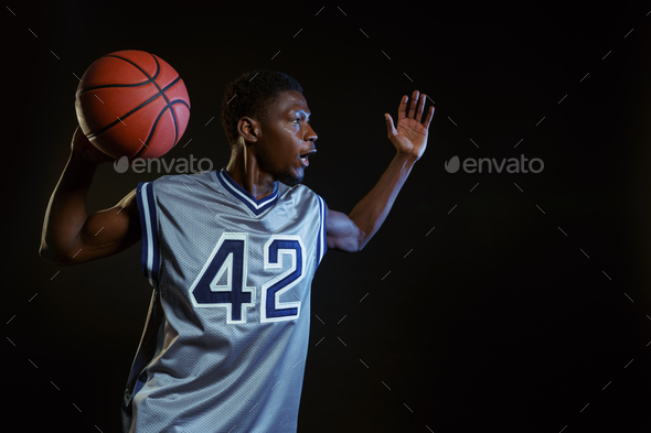 Aggressive basketball player poses with ball Stock Photo by NomadSoul1