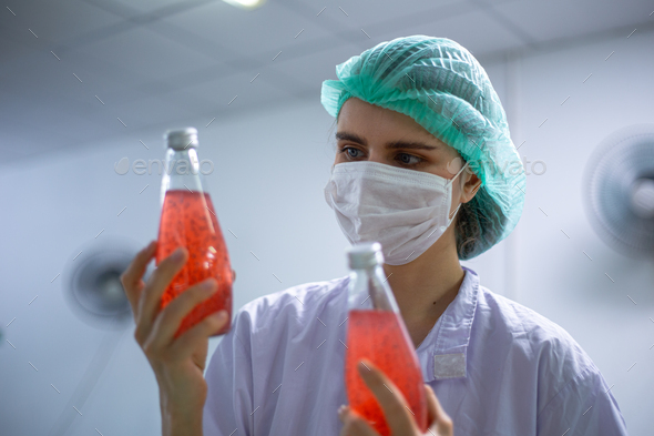 Woman worker checking quality control of juice bottle Stock Photo by ...