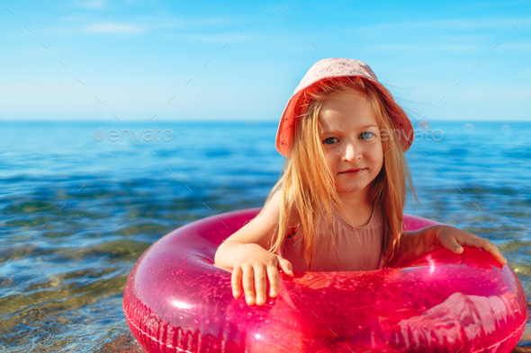 Happy little girl bathing in sea with pink circle Stock Photo by ...