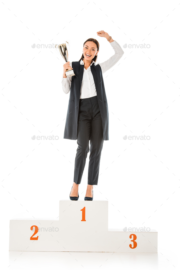 excited business winner holding trophy cup while standing on winners ...
