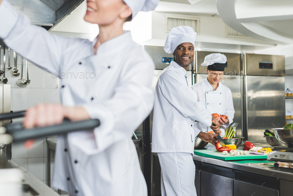 smiling multicultural chefs cooking at restaurant kitchen Stock Photo ...