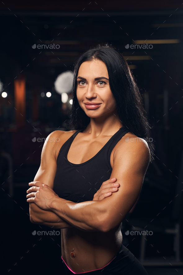 Well-built brunette lady standing wiht her arms crossed Stock Photo by ...