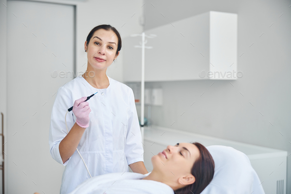 Calm friendly dermatologist treating her patient skin Stock Photo by ...