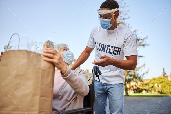 Friendly volunteer addressing aged woman with disability Stock Photo by ...