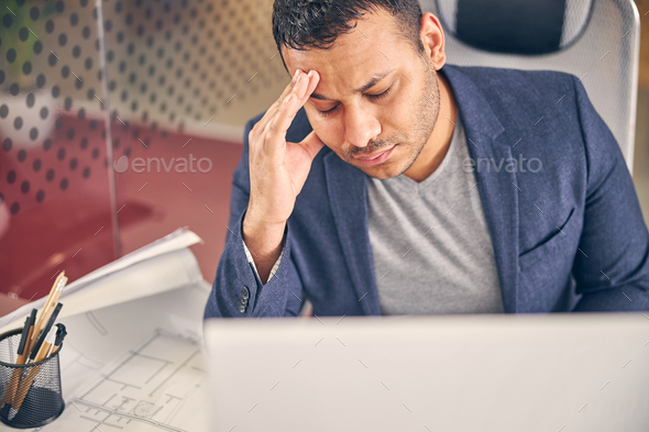Kind male person trying to concentrate on task Stock Photo by Iakobchuk