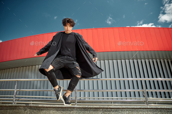 Handsome young man standing on one leg on the street Stock Photo by ...