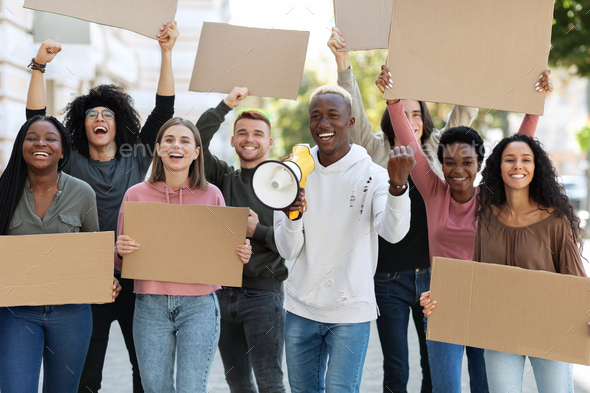 Motivated black man with loudspeaker over crowd with empty placards ...