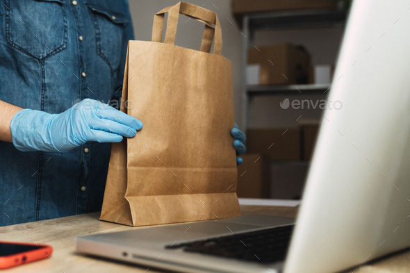 Courier preparing parcel package for delivery wearing protective gloves ...