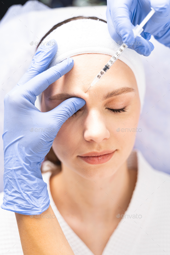 Pretty woman getting injection into the forehead Stock Photo by Iakobchuk