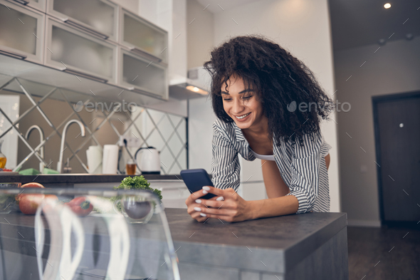 Smiling pretty girl reading a text message Stock Photo by Iakobchuk
