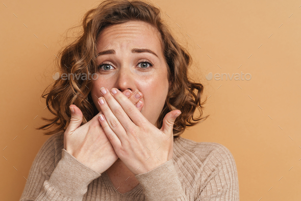 Young ginger scared woman with wavy hair covering her mouth Stock Photo ...