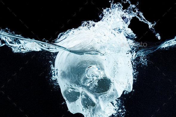 Skull model diving into the water against black background Stock Photo ...