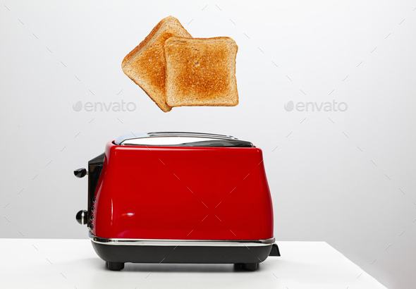 Two toasts jumping out of red toaster against white background Stock ...