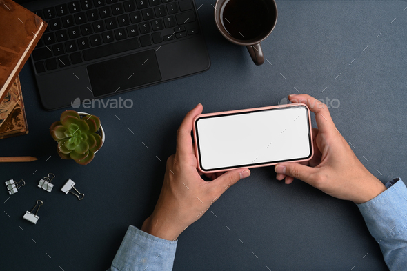 Overhead shot of businessman holding horizontal smart phone with blank ...