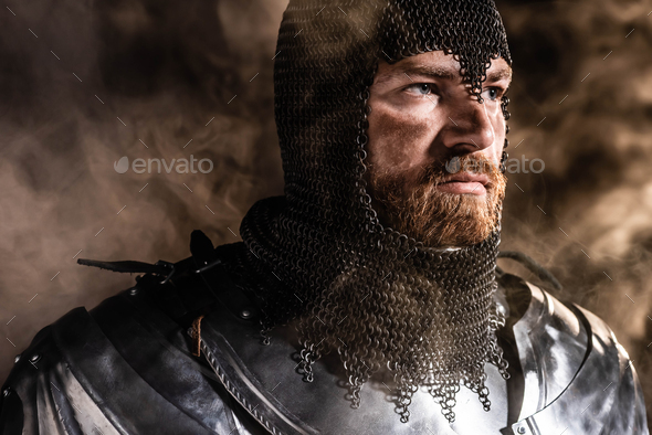 handsome knight in armor looking away on black background Stock Photo ...