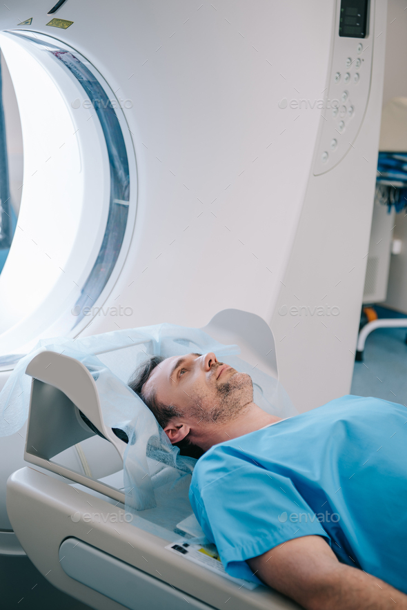 handsome man lying on ct scanner bed while having tomography test Stock ...