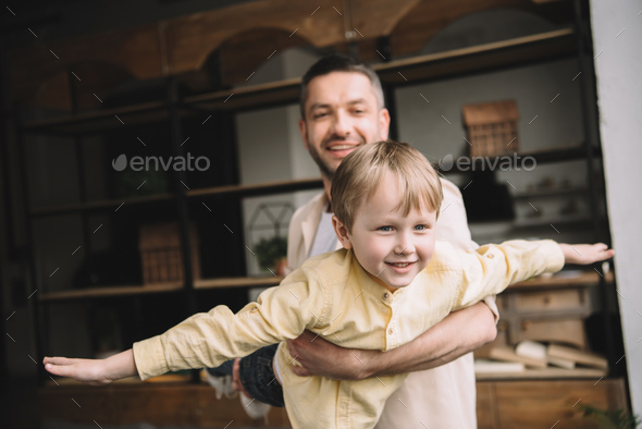happy daddy having fun with adorable smiling son at home Stock Photo by ...