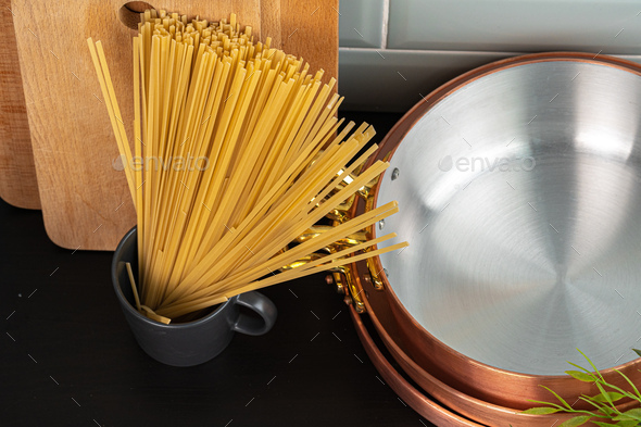Dry spaghetti on a kitchen counter with cooking utensils Stock Photo by ...