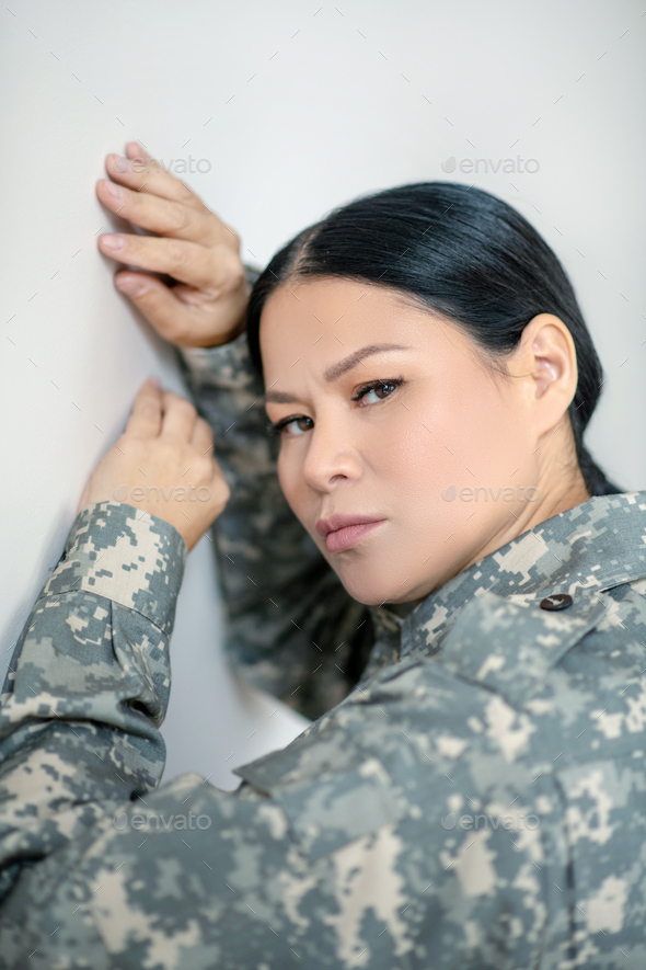 Servicewoman wearing military uniform standing near wall Stock Photo by ...