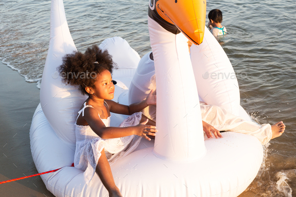 African girl playing on goose rubber ring at the beach Stock Photo by ...