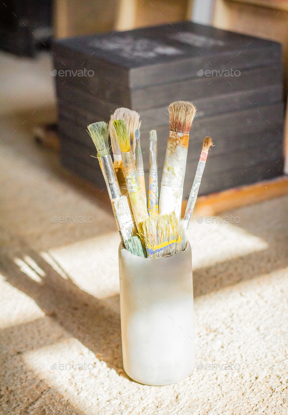 Set of paint brushes in front of canvas Stock Photo by davidpereiras