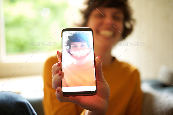 Close up happy woman sitting at home showing mobile phone screen with ...