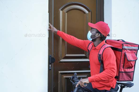 African american delivery man with bicycle ringing on doorbell while ...