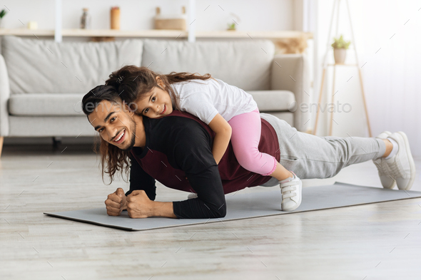 Happy sporty father and kid bonding while training at home Stock Photo ...