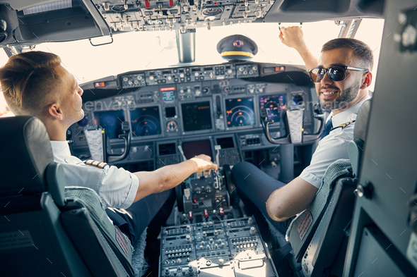 Two handsome male sitting in the cabin of aircraft Stock Photo by svitlanah