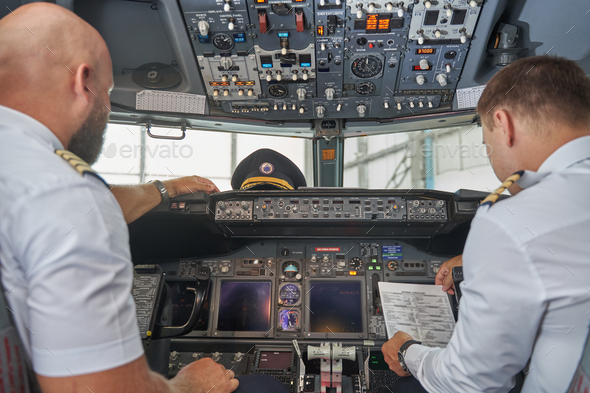 Aircraft cockpit with two colleagues in it Stock Photo by svitlanah