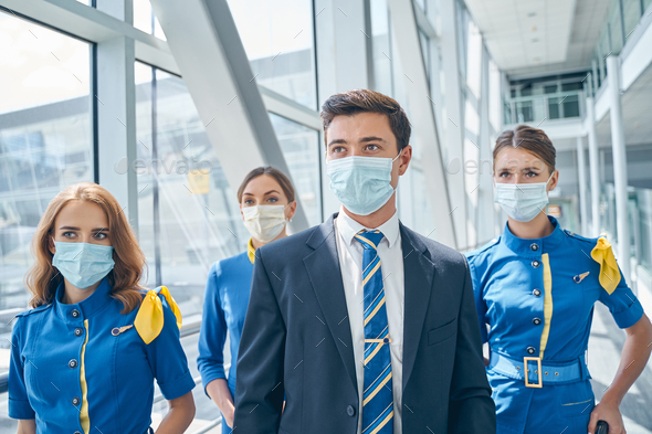 Serious steward and his colleagues standing at the airport Stock Photo ...