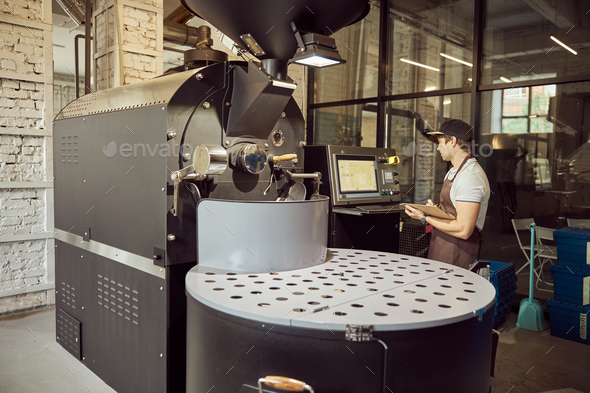 Male worker using control panel of coffee roasting machine Stock Photo ...