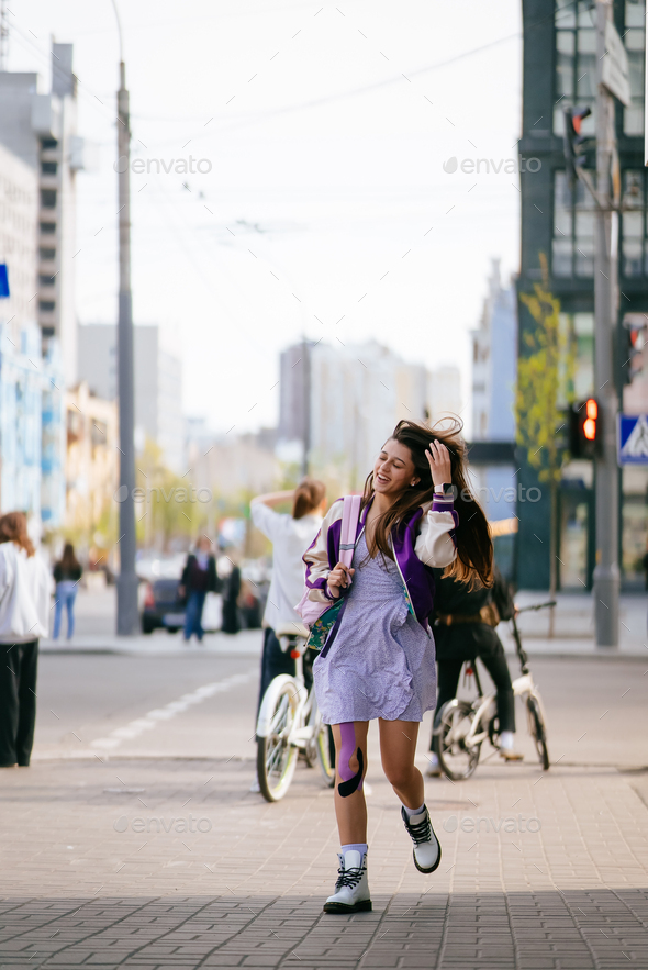 Pretty young woman, walking at the street Stock Photo by simbiothy