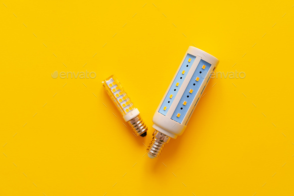 Light bulb on yellow paper background top view Stock Photo by FabrikaPhoto