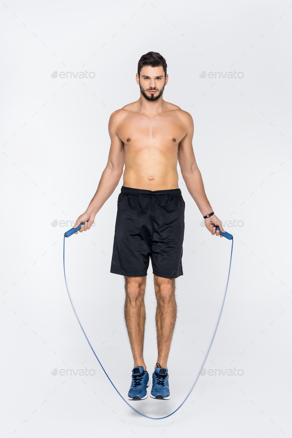 young shirtless sportsman jumping over rope isolated on white Stock ...