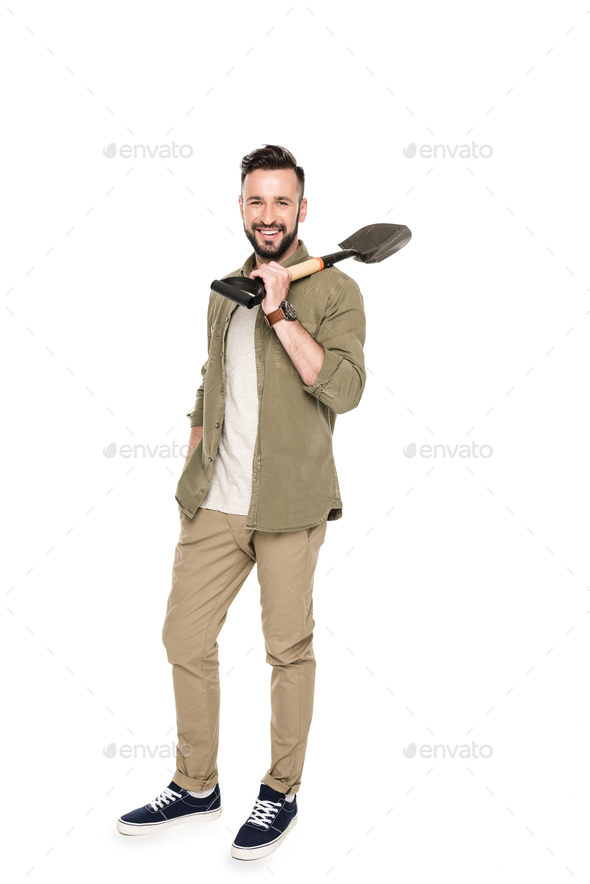 smiling man holding shovel on his shoulder and looking at camera ...