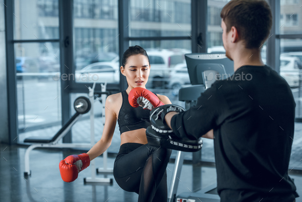 young female fighter performing low kick with trainer at gym Stock ...