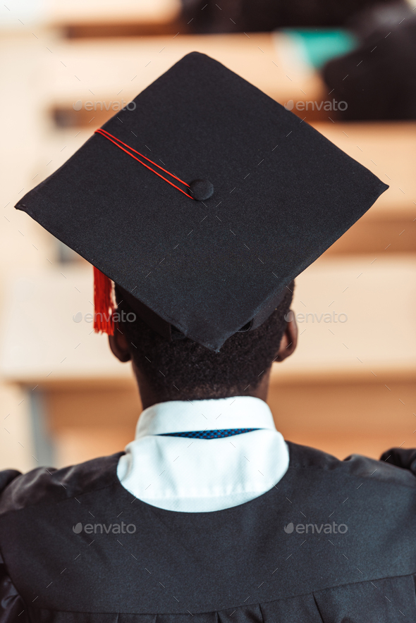 back view of african american student in graduation hat sitting in ...