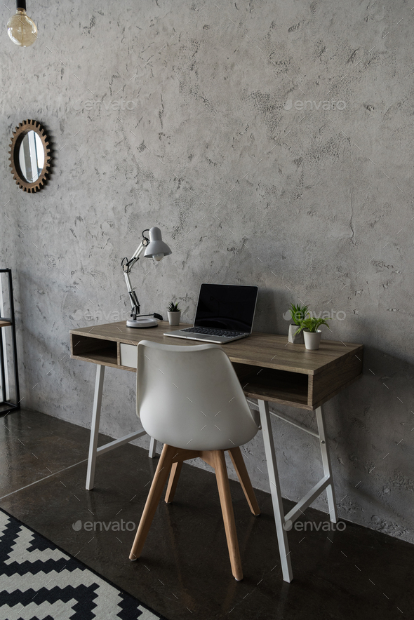workplace with laptop computer and flower pots in modern office Stock ...