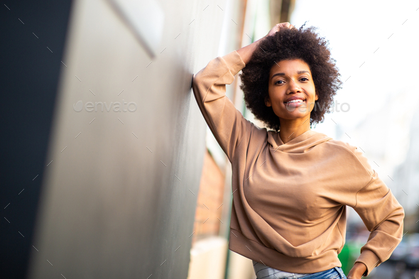 smiling African american beautiful woman leaning against wall Stock ...