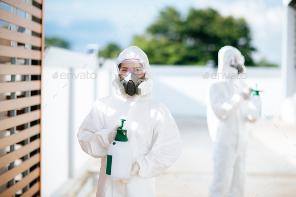 Disinfection specialist team in PPE suit performing public ...
