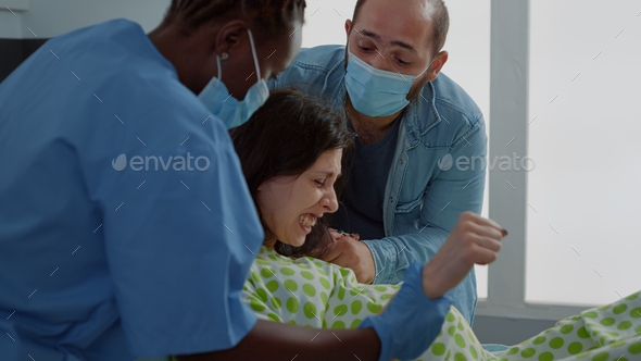 Young woman in labor giving birth to baby in hospital ward Stock Photo ...