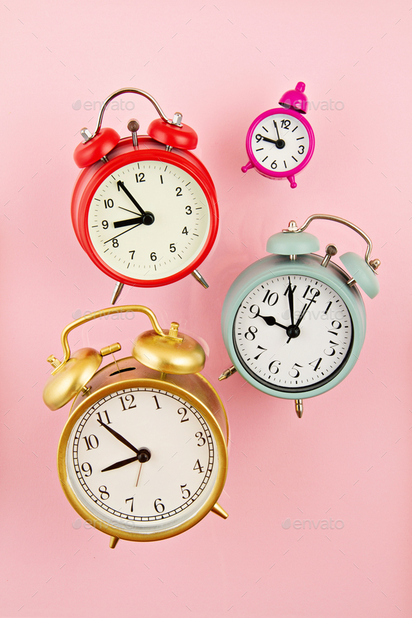 Collection of bright colorful alarm clocks over the pink background ...